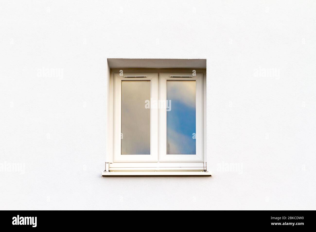 A single white window on a white house wall Stock Photo - Alamy