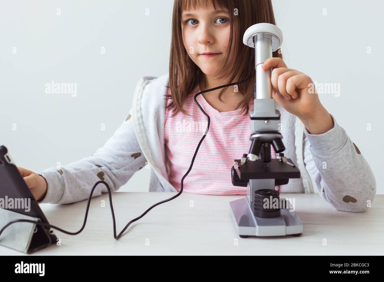 Child girl in science class using digital microscope. Technologies ...