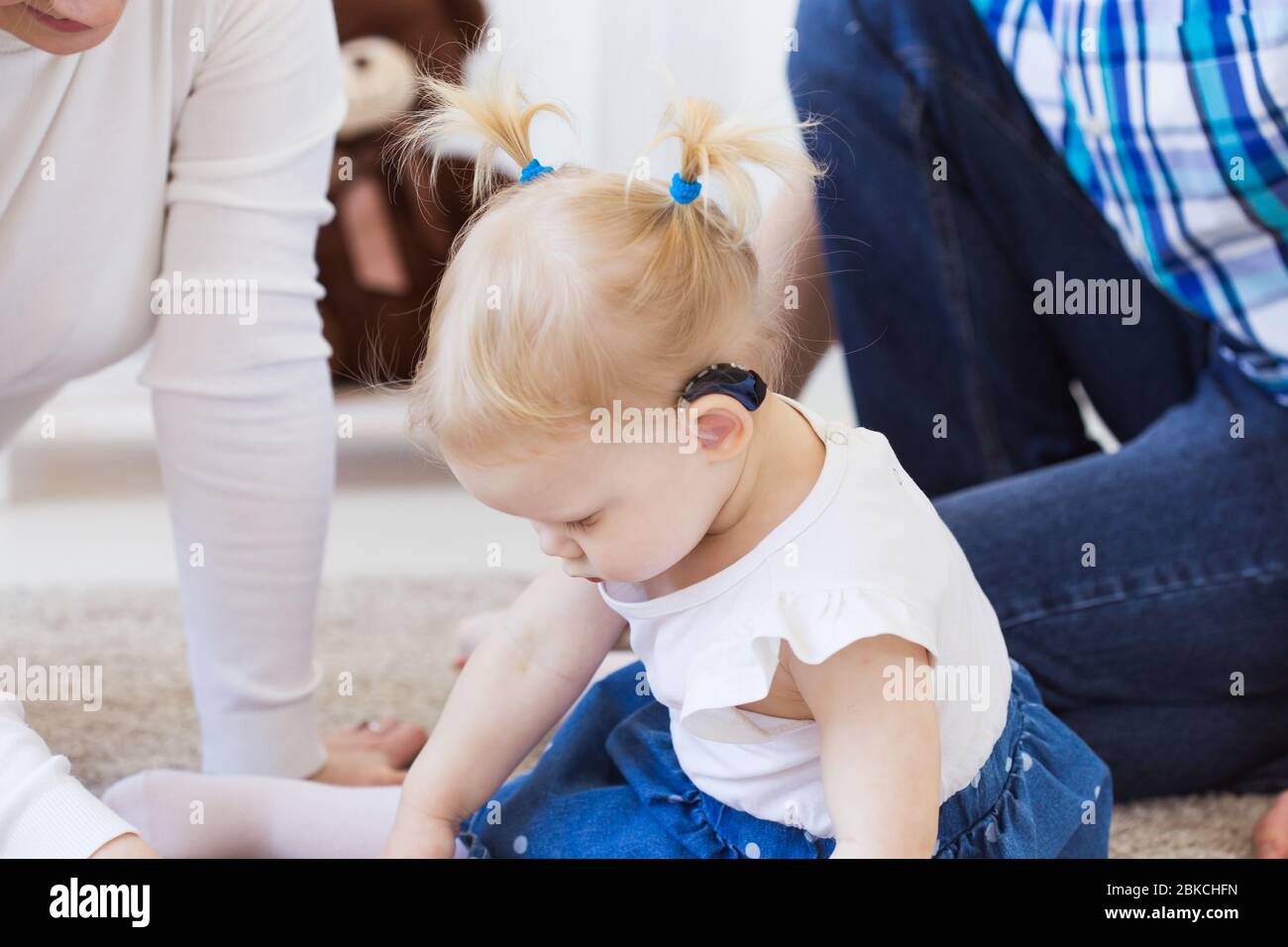 Baby girl wearing a hearing aid. Disabled child, disability and ...