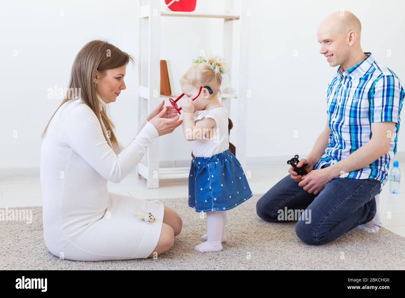 Baby girl wearing a hearing aid. Disabled child, disability and ...