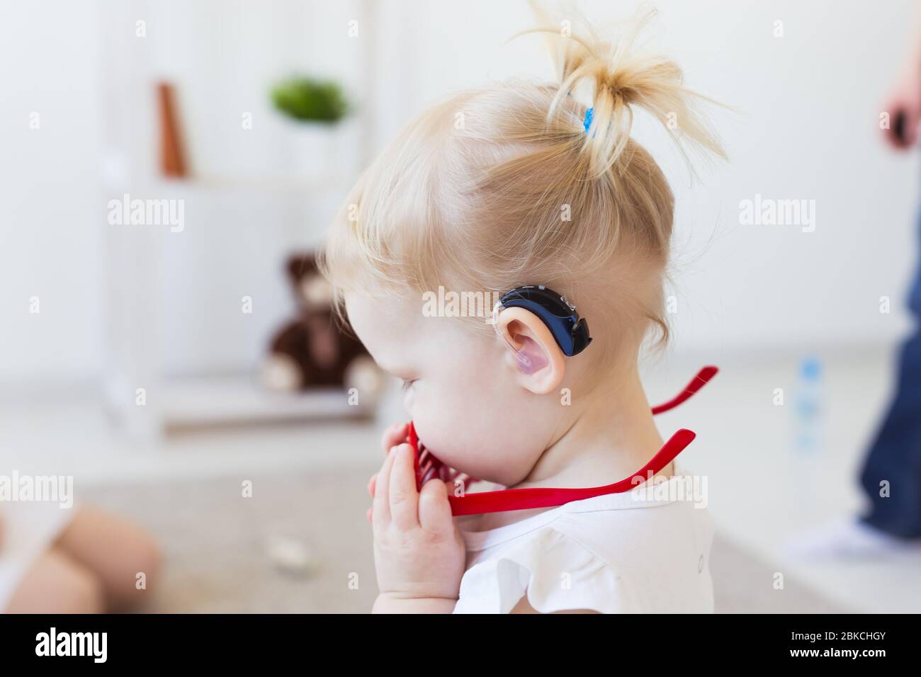 Baby girl wearing a hearing aid. Disabled child, disability and ...
