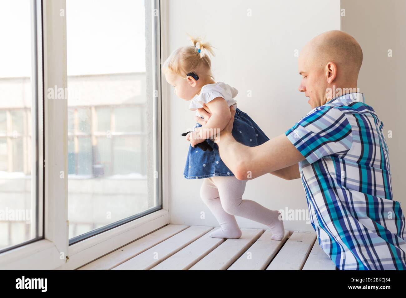 Baby girl wearing a hearing aid. Disabled child, disability and ...
