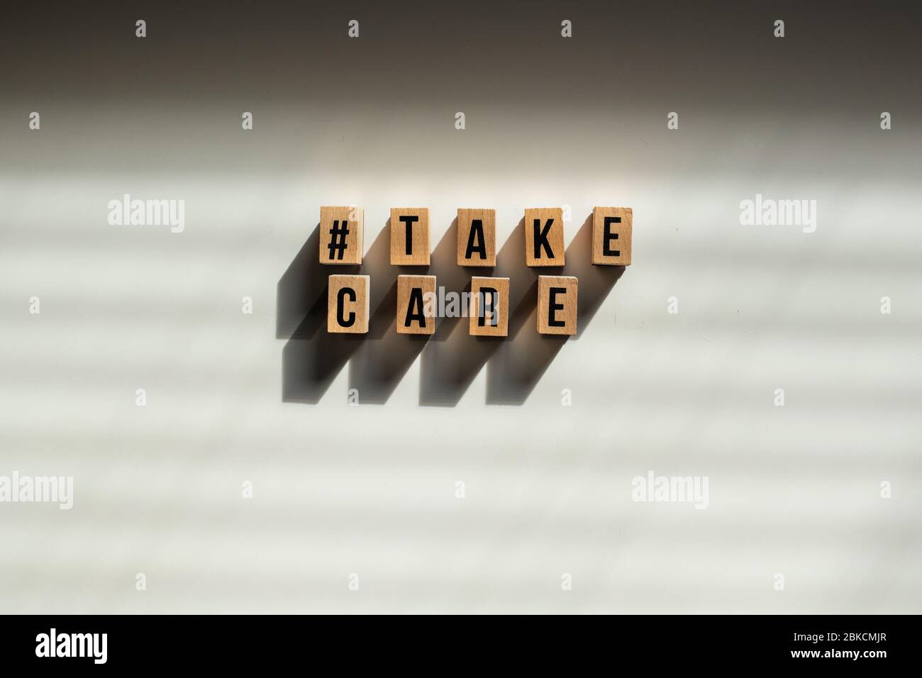 " Take care " text made of wooden cube on White background with shadow ...