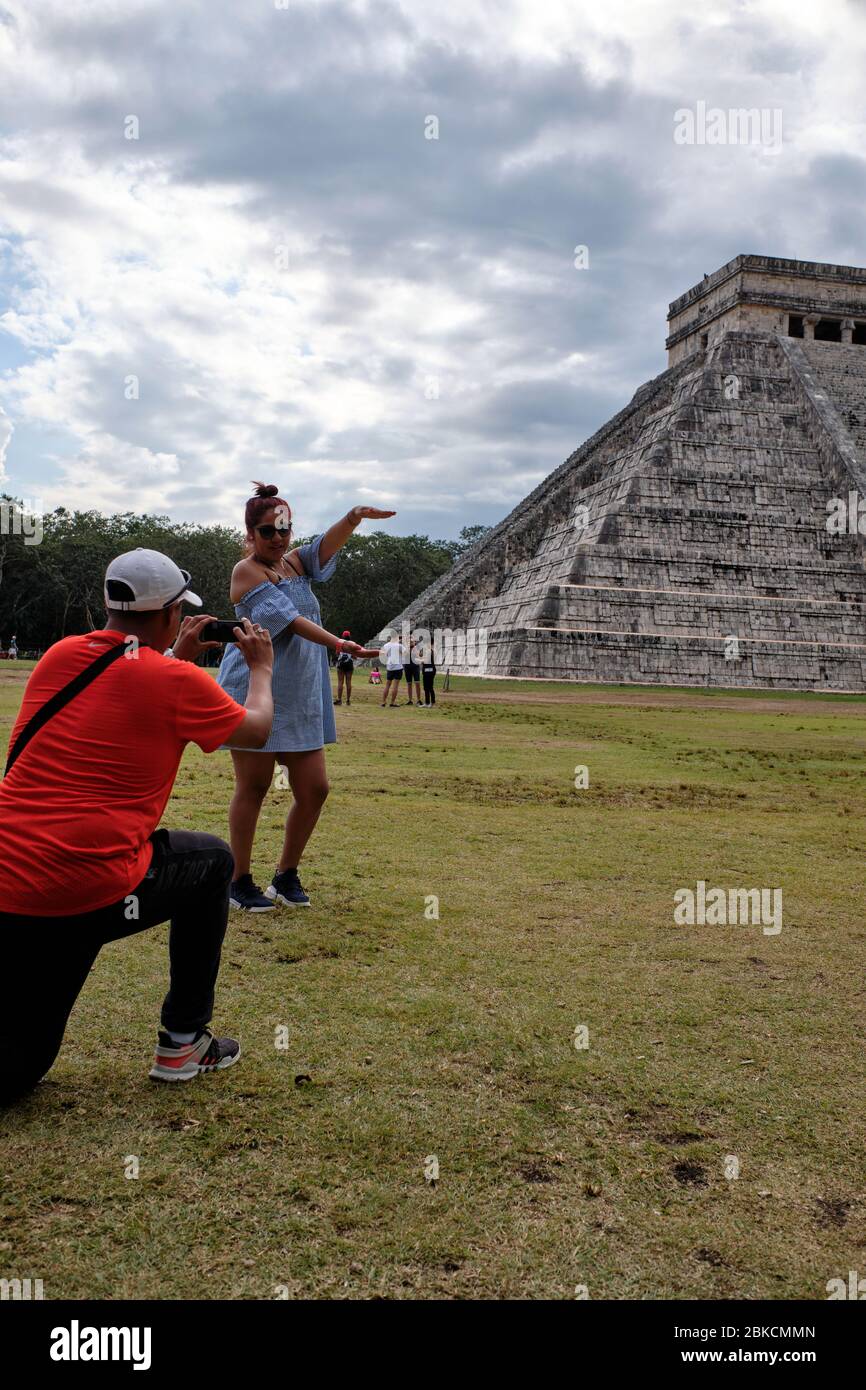 Tourists visiting the pyramids of the Chichen Itza archaeological site ...
