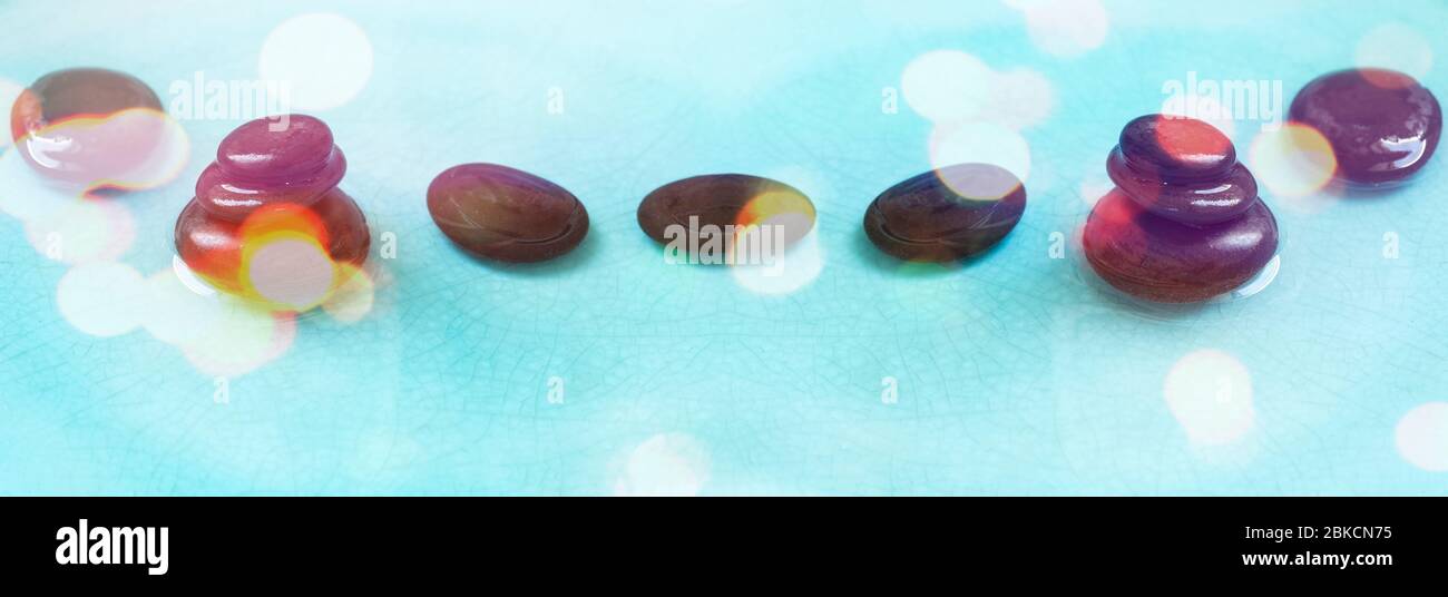 Spa pebbles in blue water Stock Photo - Alamy