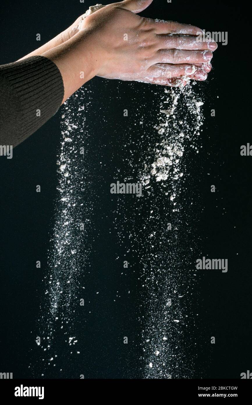 hand of woman cook in kitchen pouring white dust flour flour table for ...