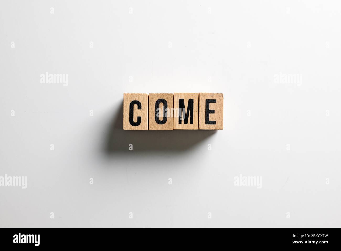 " come " text made of wooden cube on White background Stock Photo - Alamy