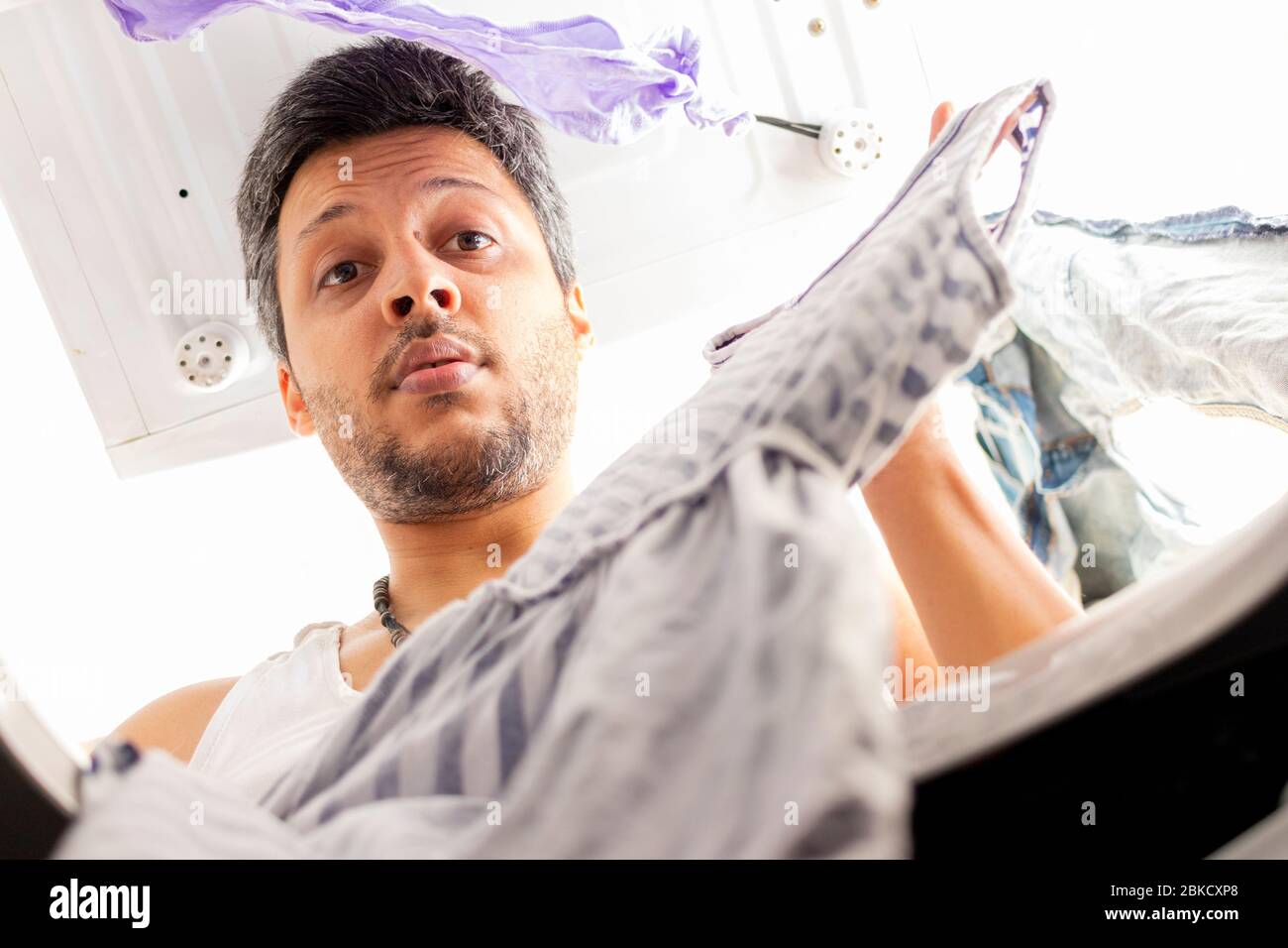 Bearded man using washing machine at home Stock Photo - Alamy