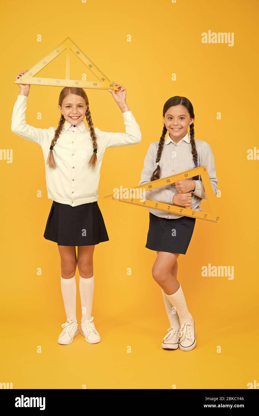 Measuring angles at geometry. Cute schoolgirls holding triangles for ...