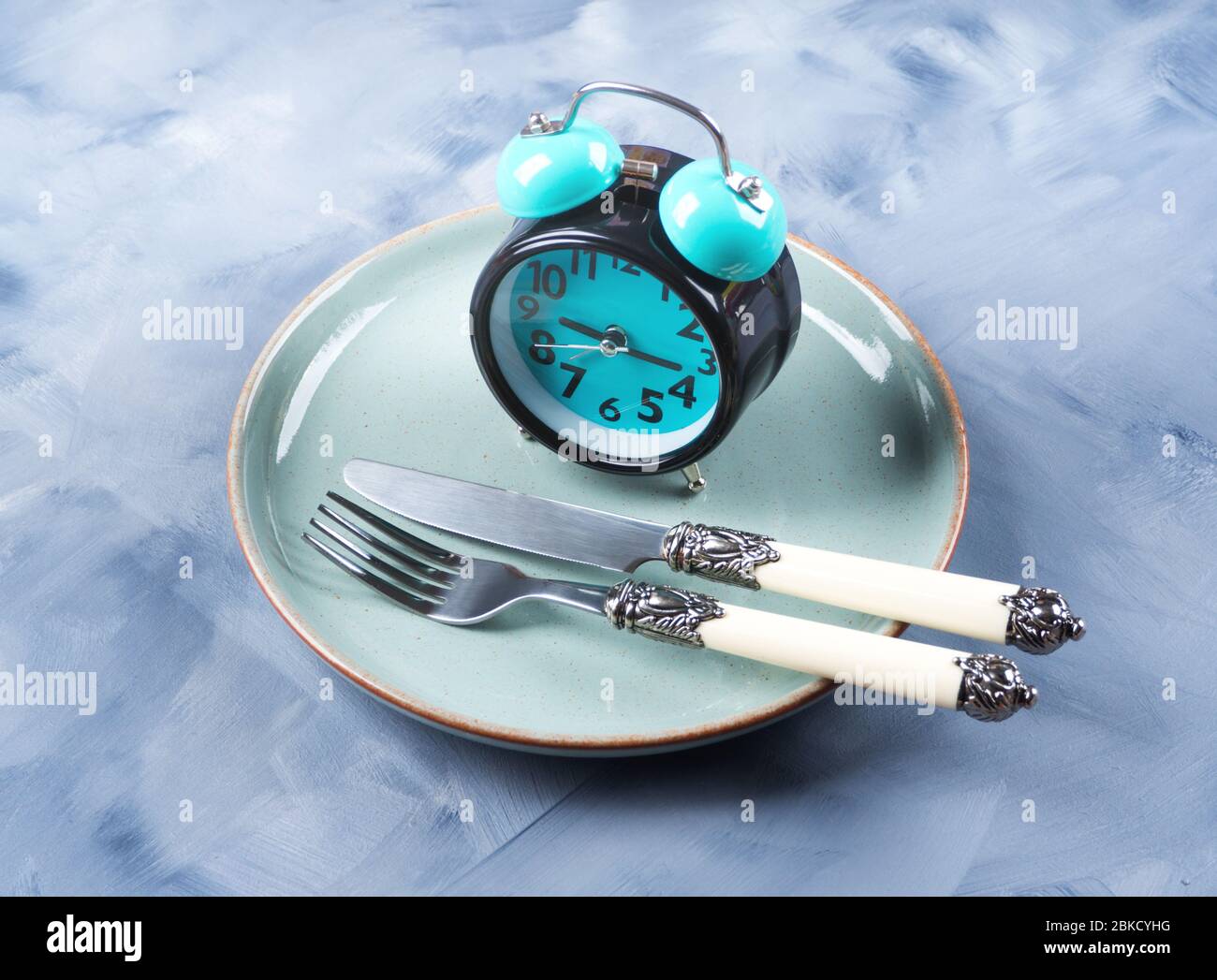 Intermittent fasting concept with blue alarm clock Stock Photo - Alamy