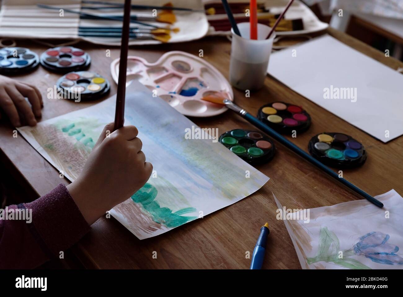 Child painting with paints. Home school. Art work at home. A place to ...