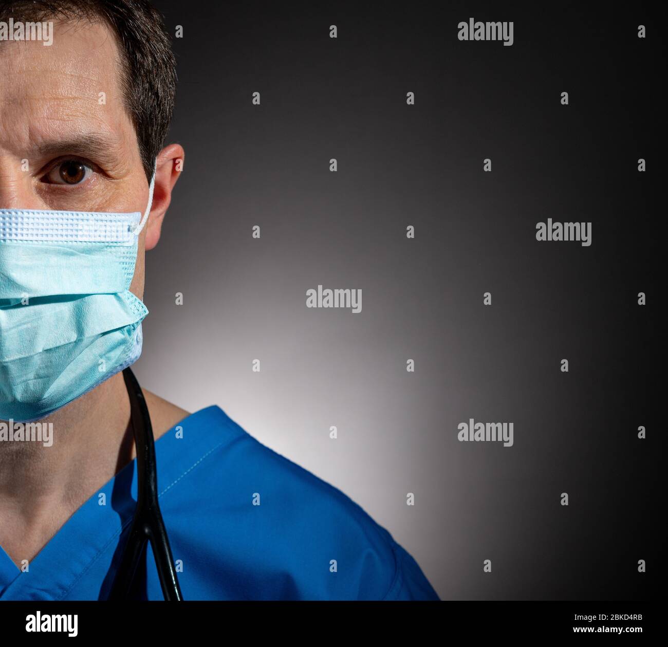 Half face portrait of doctor wearing surgical mask, blue hospital ...