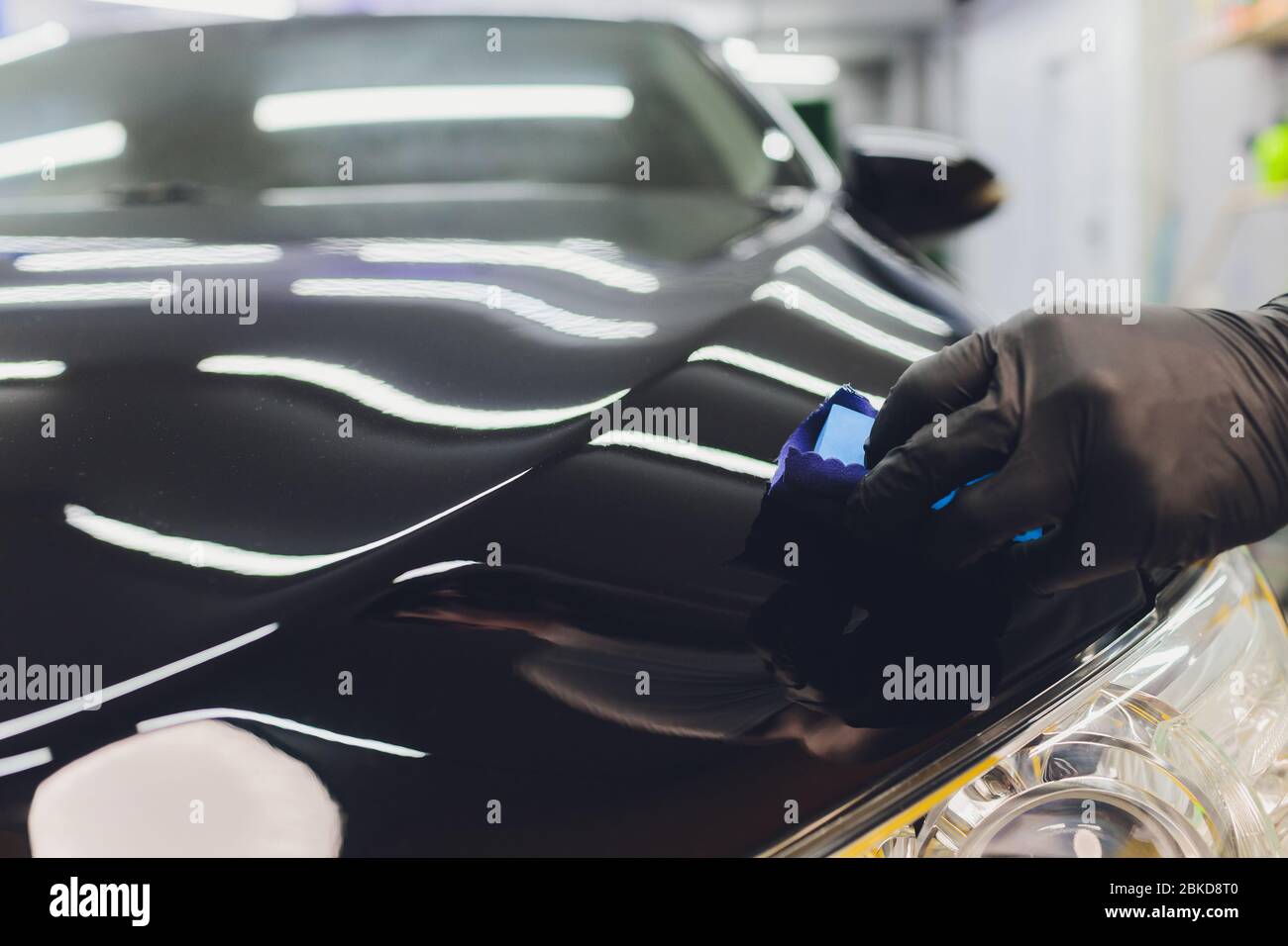 Car detailing - Man applies nano protective coating to the car ...