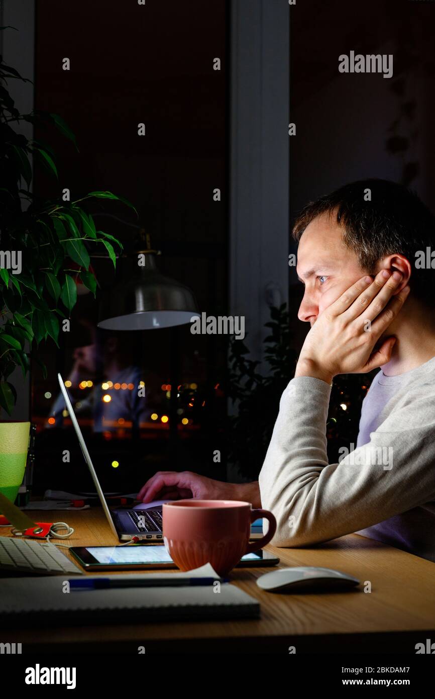 Bored man working on desktop pc late at night, can not sleep, addict ...