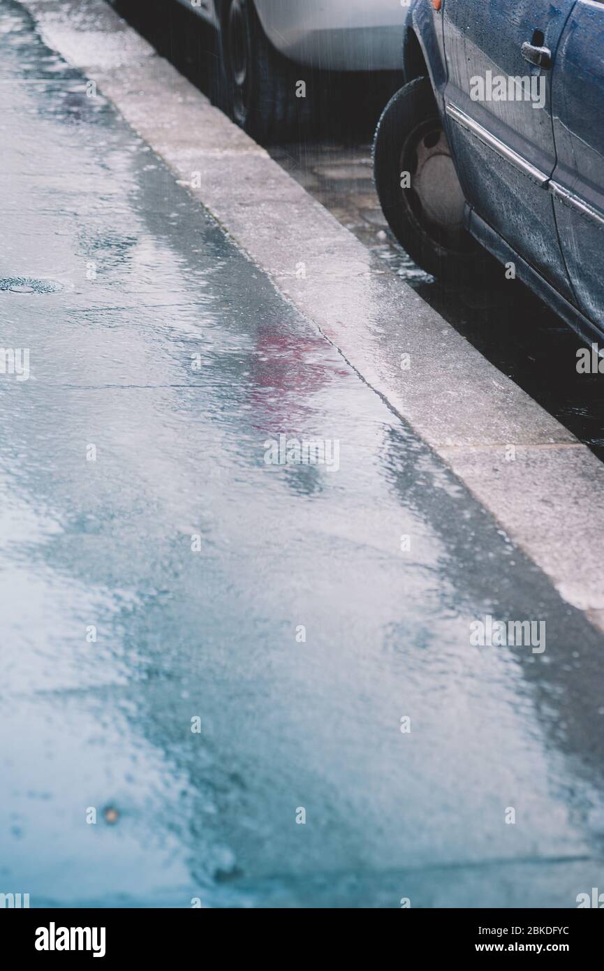 Rainy weather on empty street with cars parked near bordures Stock ...