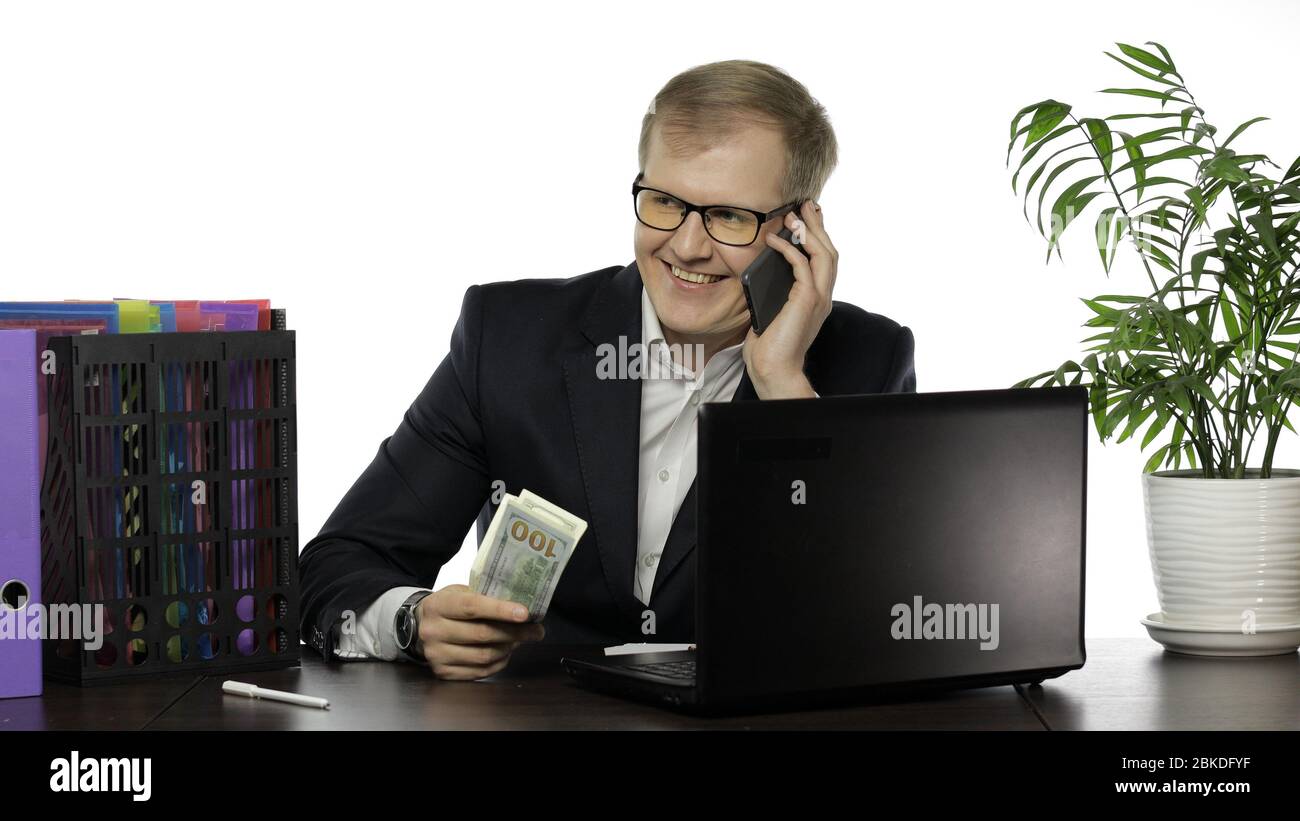 Successful company director at working desk in office with money paper ...