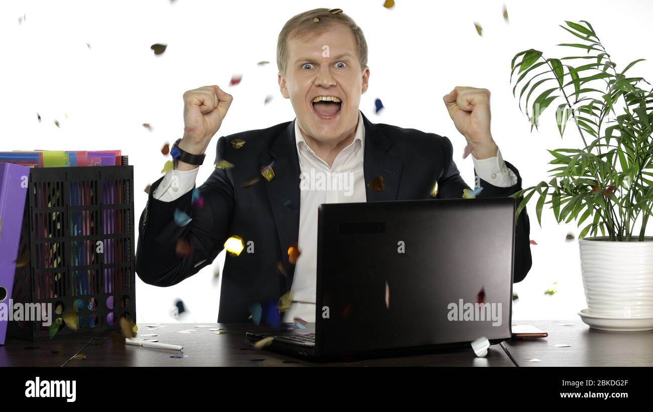 Happy businessman manager crossing fingers to win playing online game ...