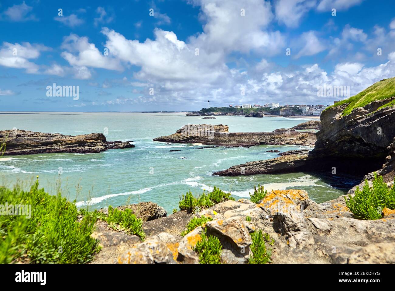 Biarritz city. Seascape. Stones, green grass, sea water and rocky shore ...