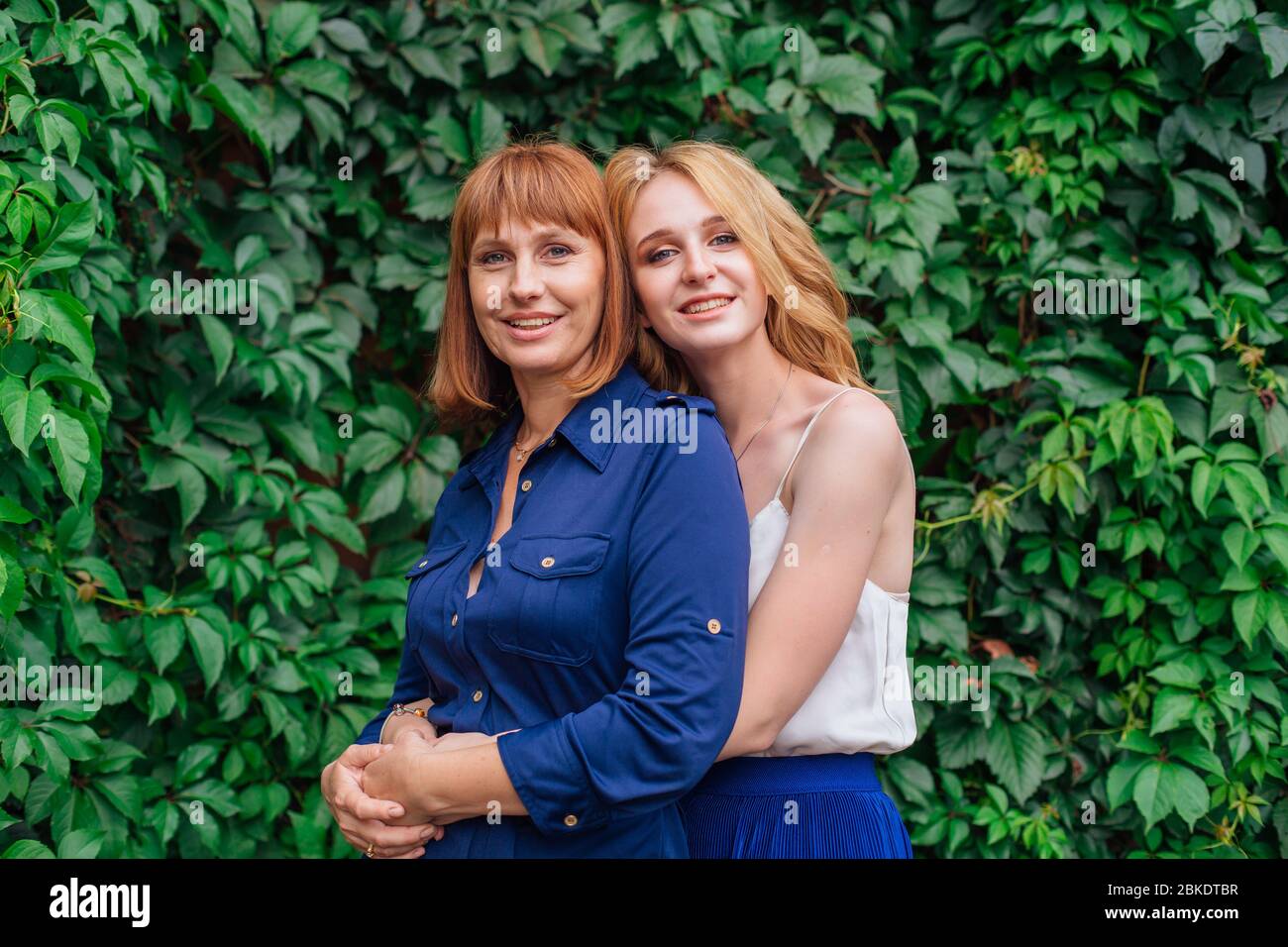 Beautiful mother and her grown up daughter hugging each other on a ...