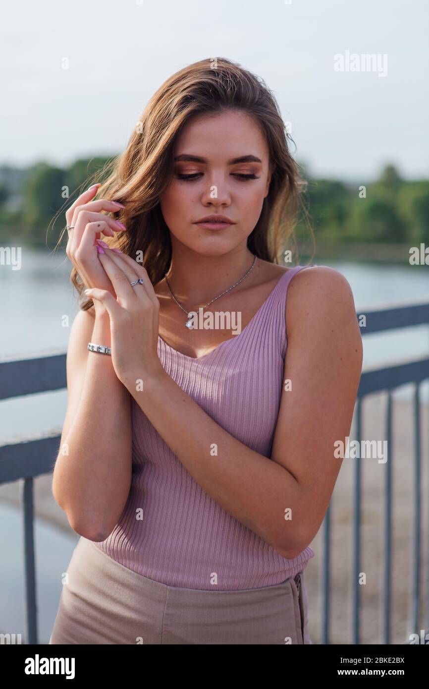 Pretty young woman posing on the old rusty transport bridge over the ...