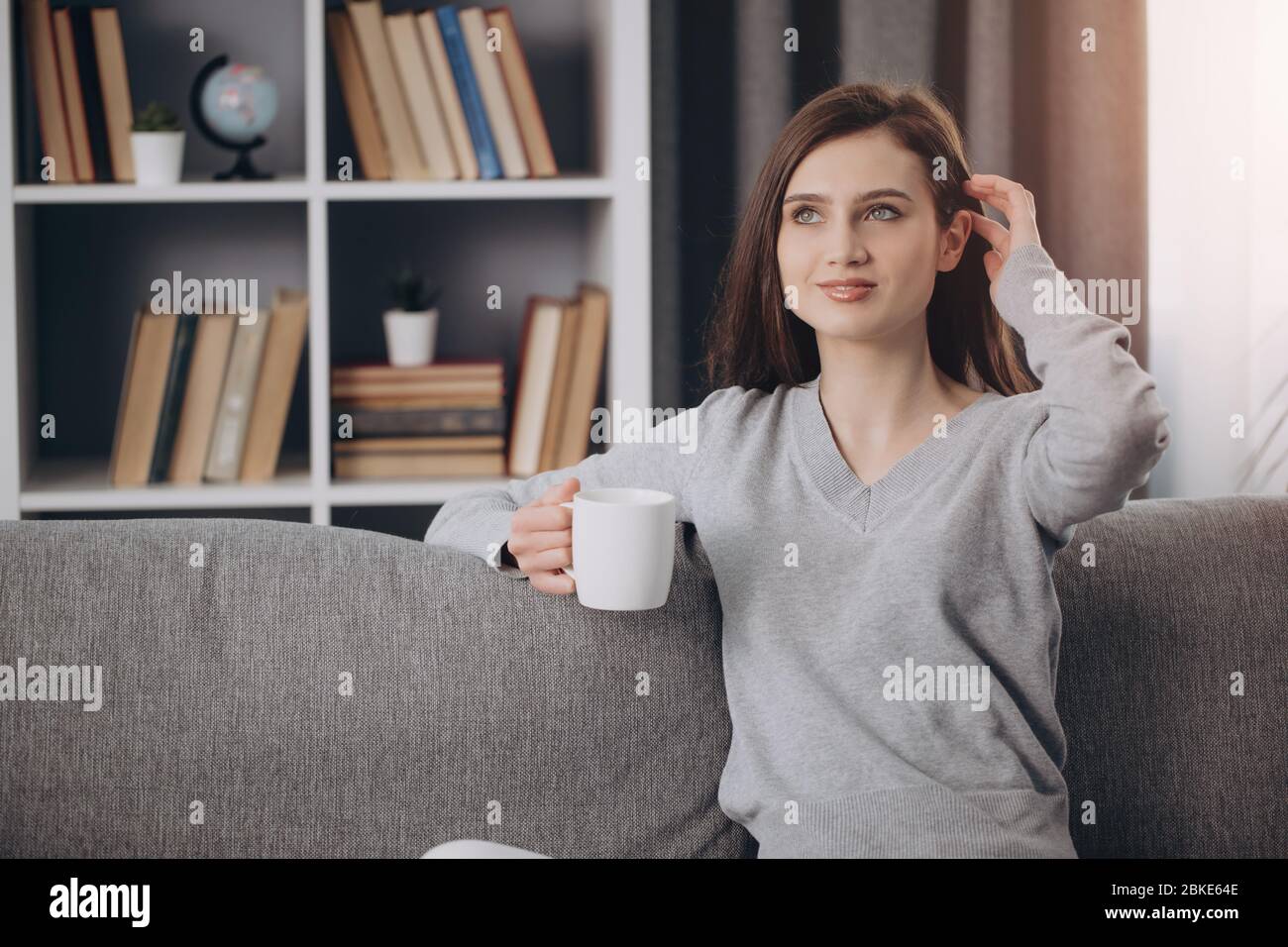 Beautiful girl sitting on couch hi-res stock photography and images - Alamy
