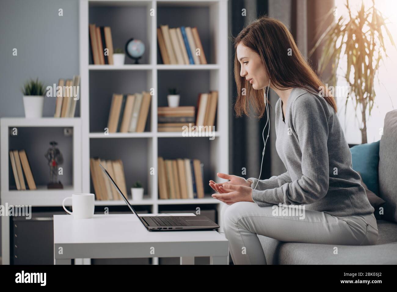Happy girl using laptop and headphones for video chat Stock Photo - Alamy
