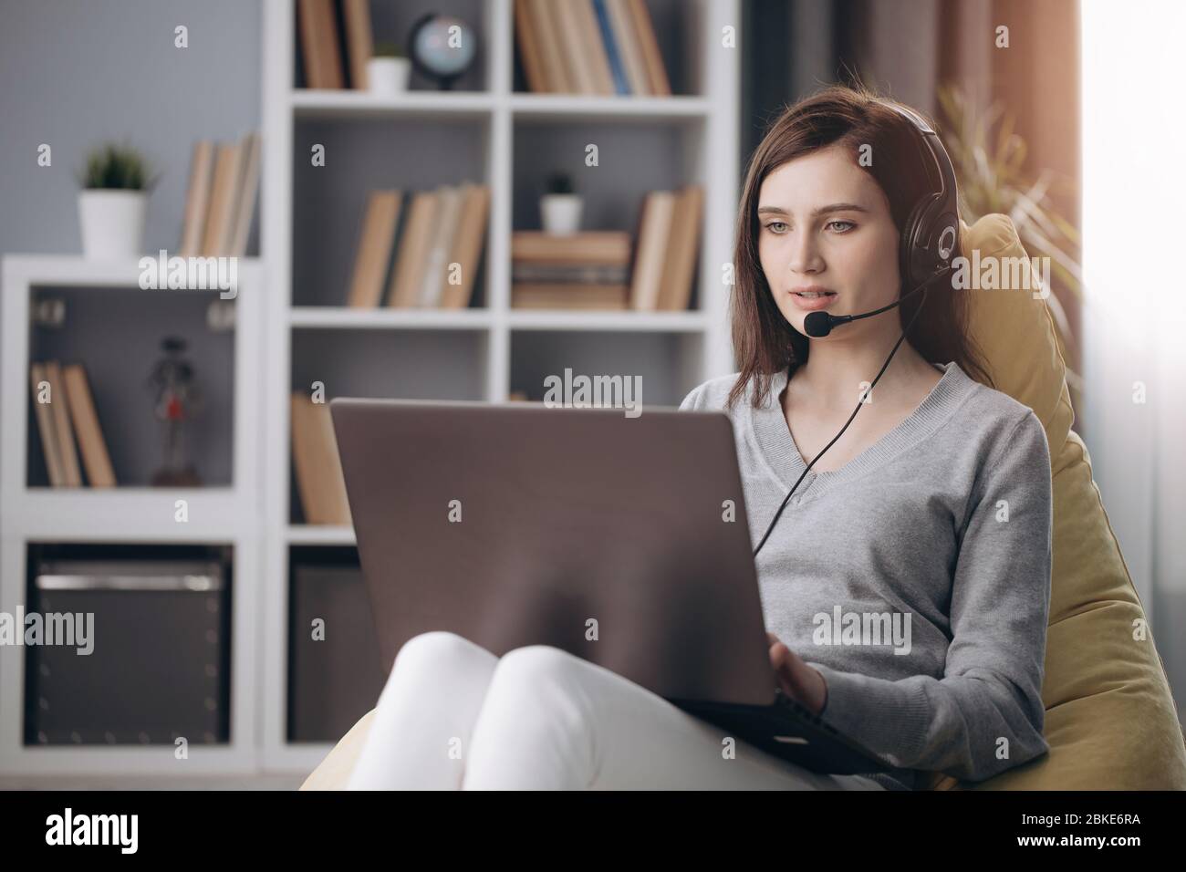 Beautiful woman using computer and headset for remote work Stock Photo ...