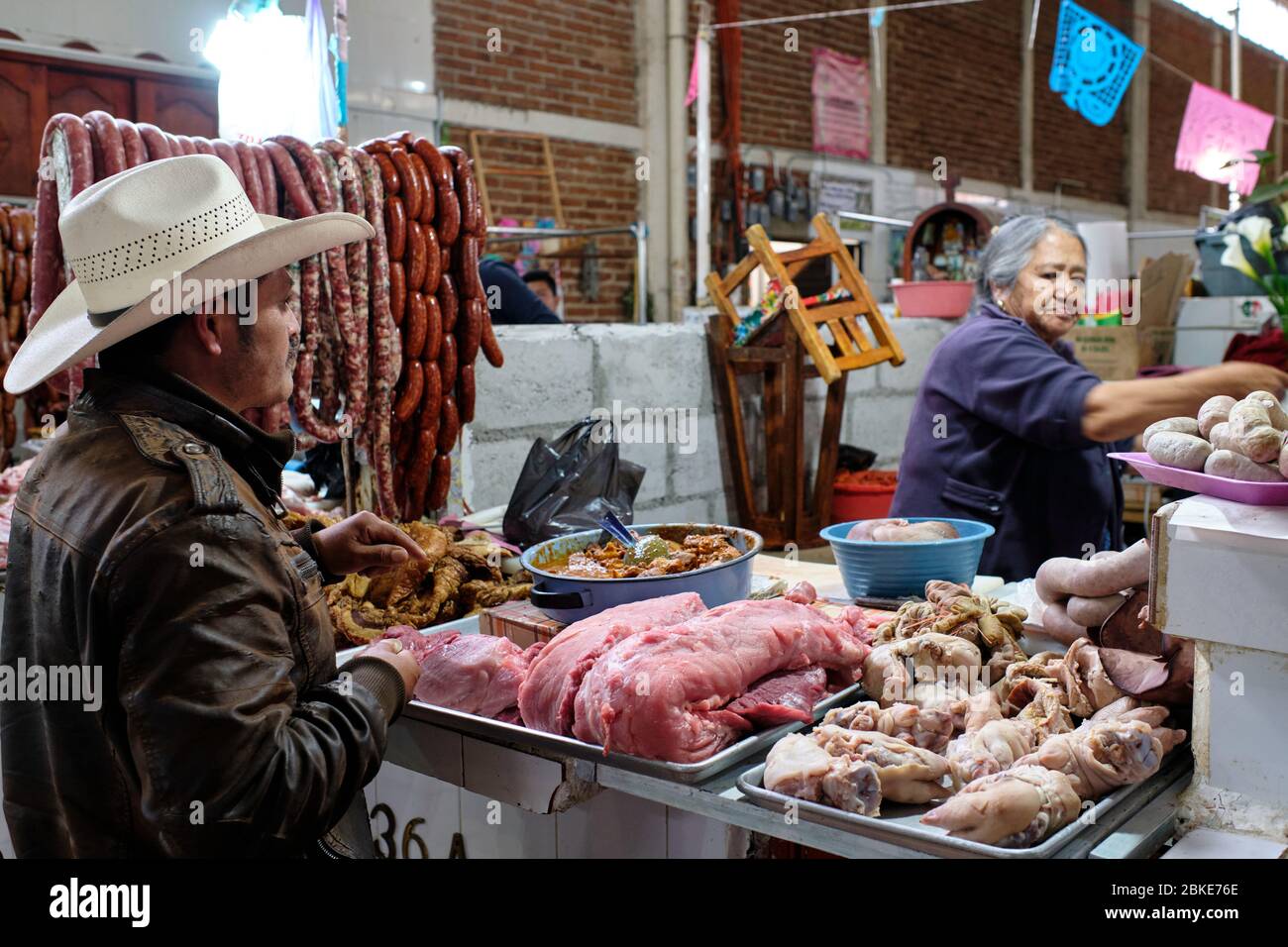Man in a cowboy hat buying meat at the San Cristobal de las Casas ...