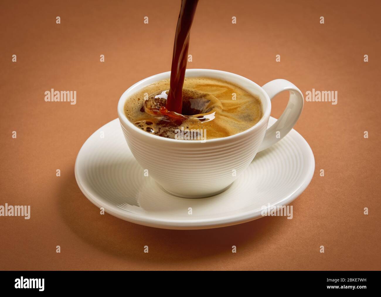 cup of pouring coffee on brown background Stock Photo - Alamy
