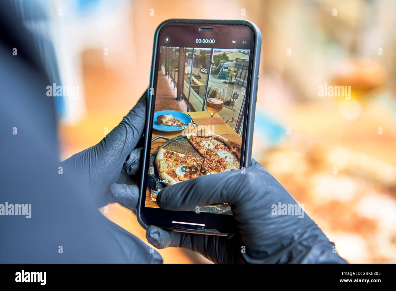 photo of food on the phone in hands with gloves Stock Photo - Alamy