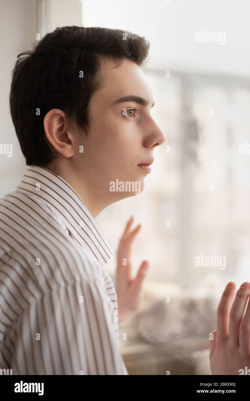 Pensive guy looking out window at home Stock Photo - Alamy