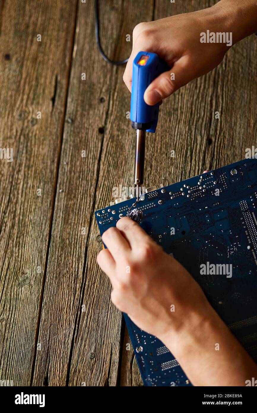 Engineer or technician repair electronic circuit board with soldering ...