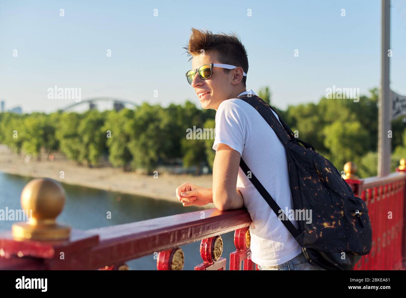Outdoor portrait of male teenager with fashionable haircut standing on ...