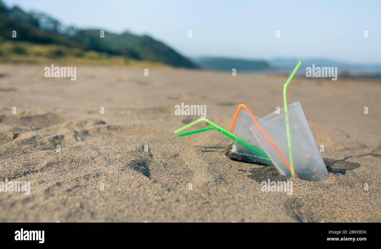 Beach with plastic cups and straws Stock Photo - Alamy