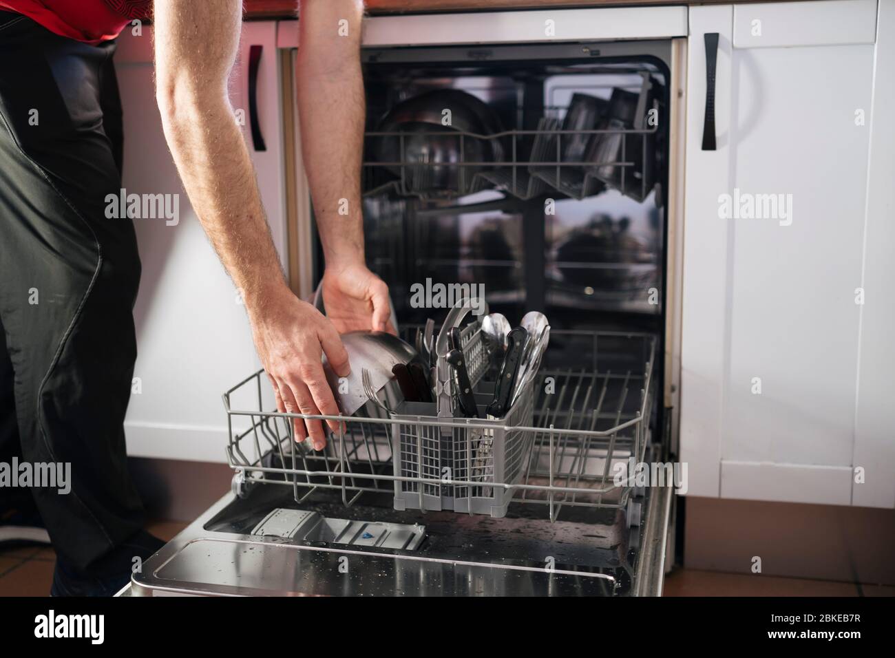 Close up of a Man Loading Dishwasher In Kitchen. Housework Stock Photo ...