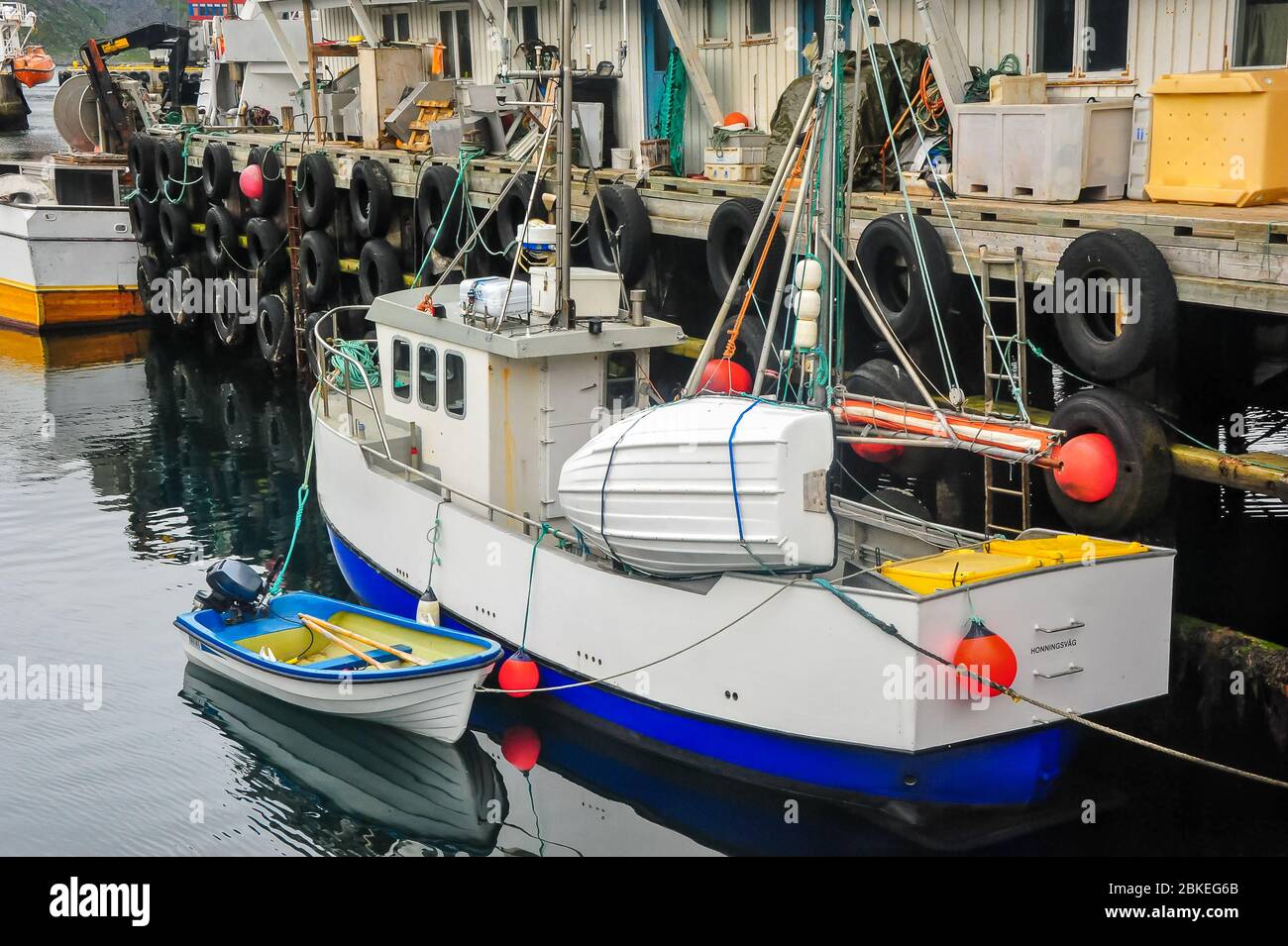 Colourful fishing boats moored at a jetty in Honningsvag harbour ...