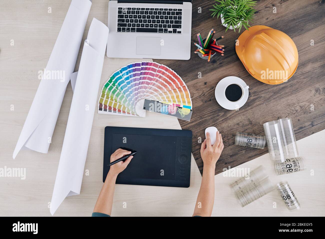 Interior designer working on graphic tablet at desk with color palette ...