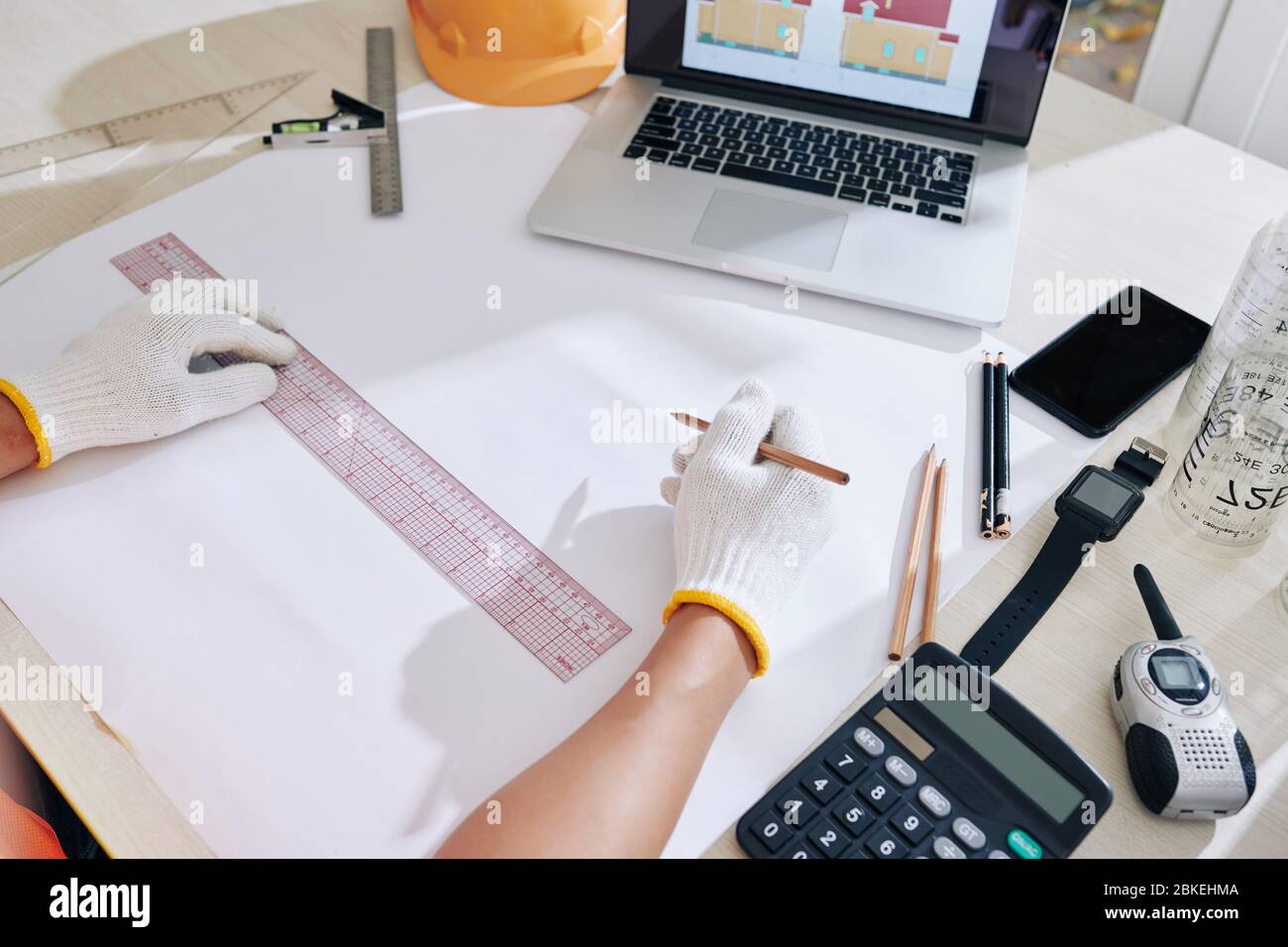Construction engineer drawing blueprint of house and checking scheme on ...