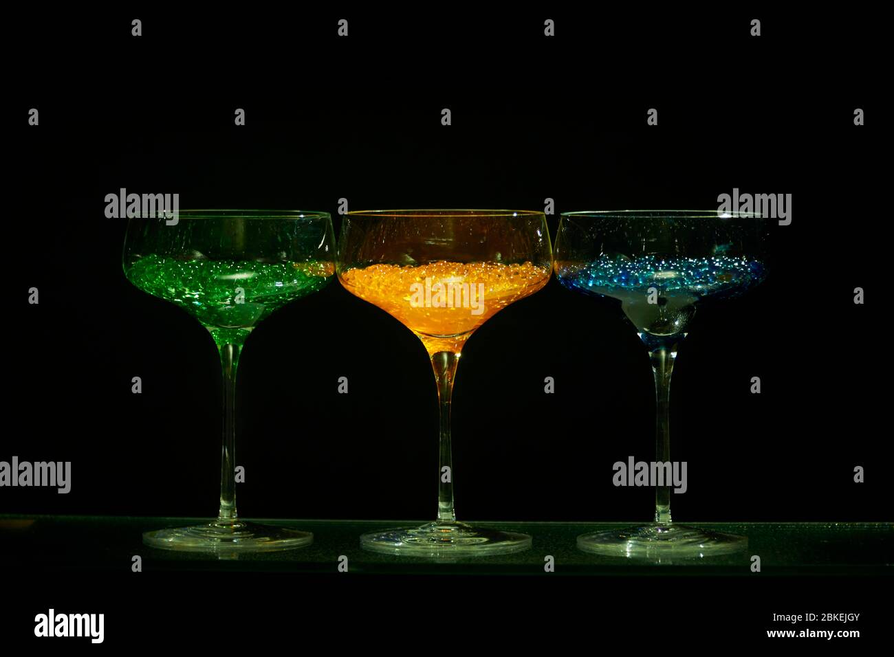 Three martini style cocktail glasses illuminated display with bright ...