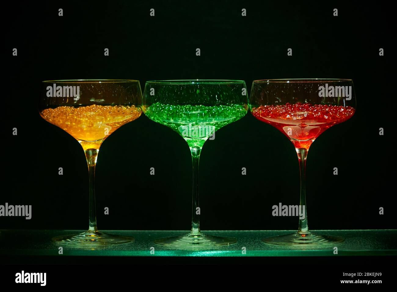 Three martini style cocktail glasses illuminated display with bright ...