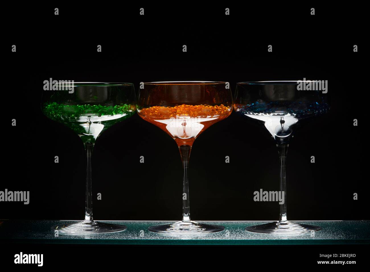 Three martini style cocktail glasses illuminated display with bright ...