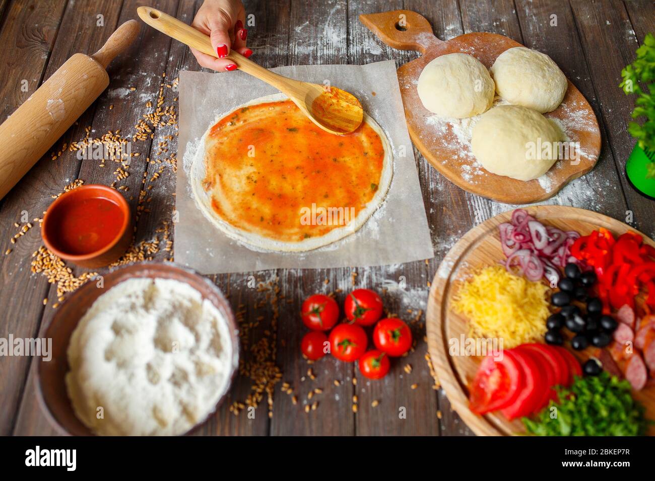 womanb hands putting souse on the dough while cooking Stock Photo - Alamy