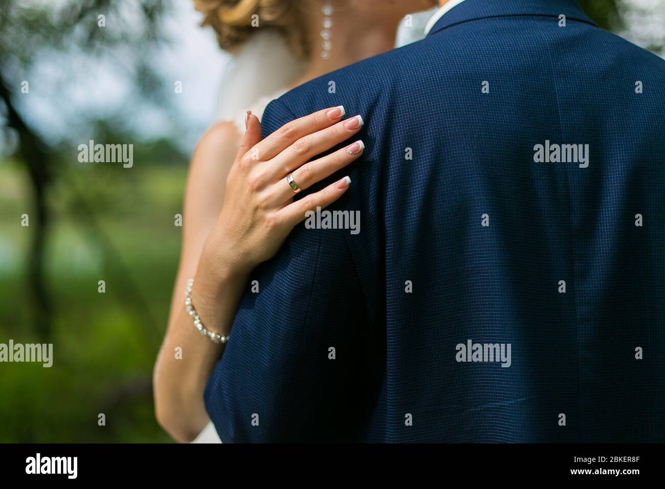 young white man gently touches the hand of his bride Stock Photo - Alamy