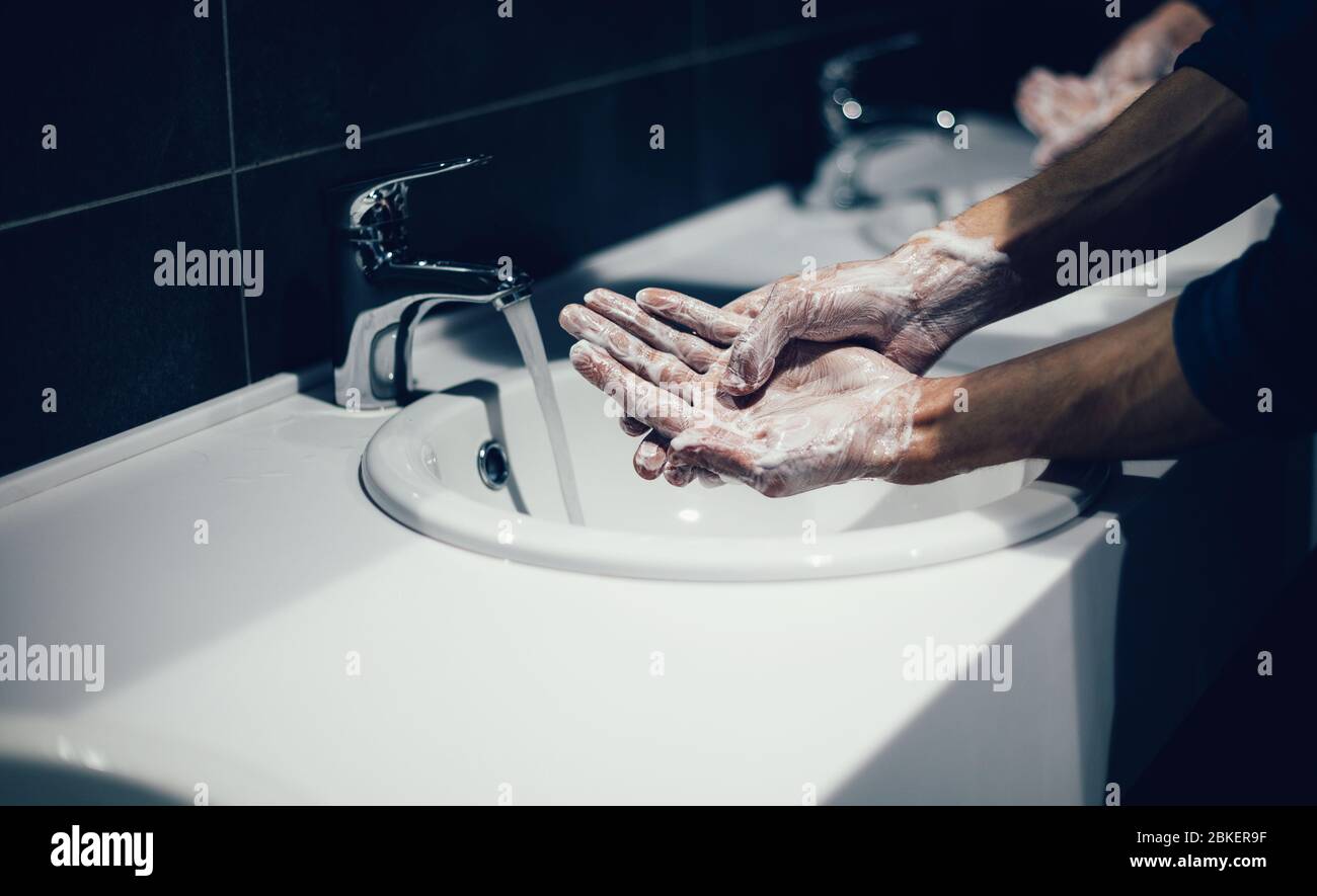 close up. young people wash their hands in a public restroom Stock ...
