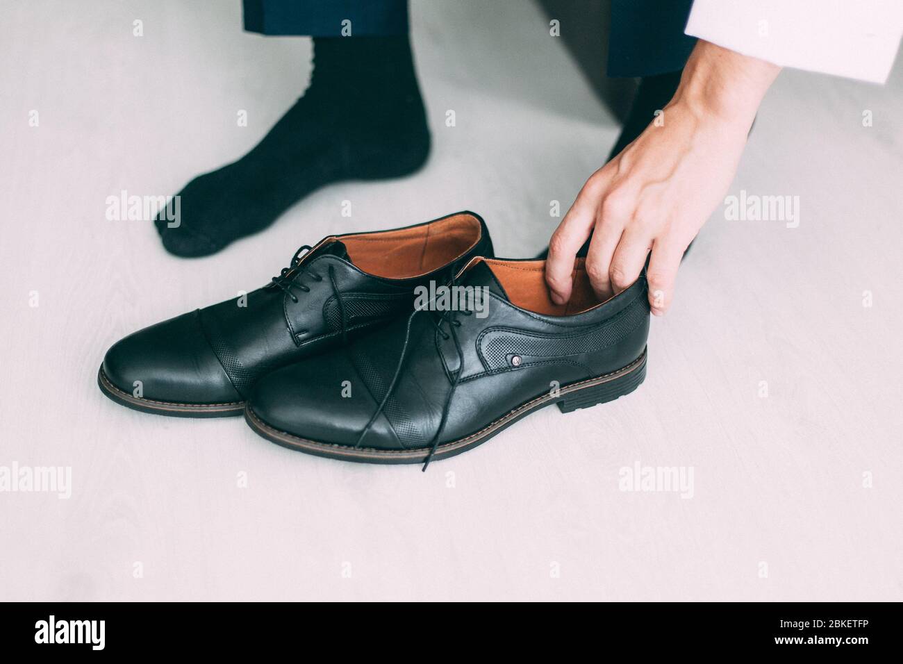 The groom puts on his shoes hi-res stock photography and images - Alamy