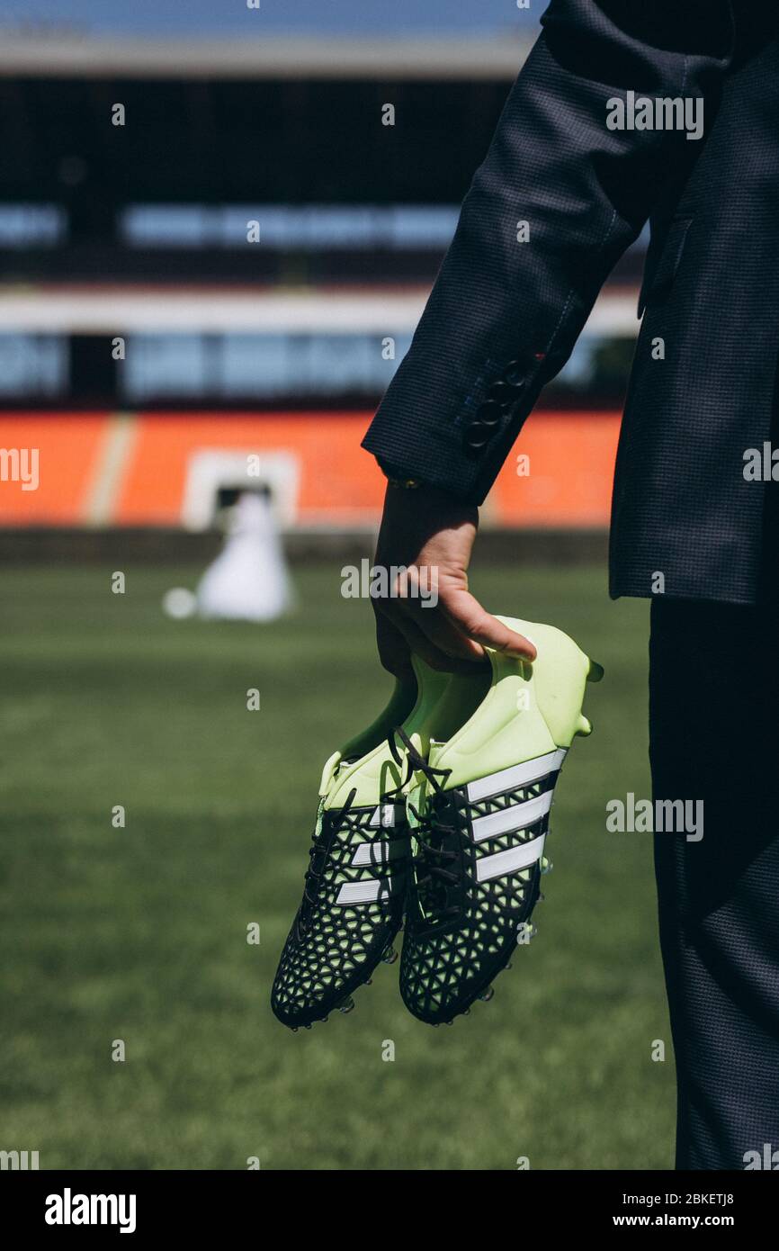 soccer player holds his boots on the football field Stock Photo - Alamy