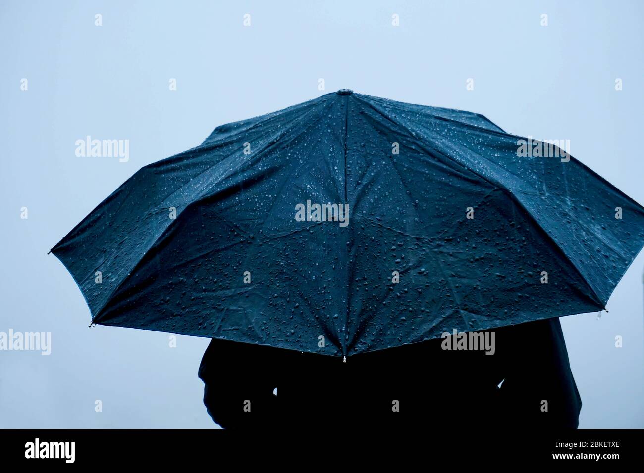 Alone man standing out in rain with an umbrella Stock Photo - Alamy