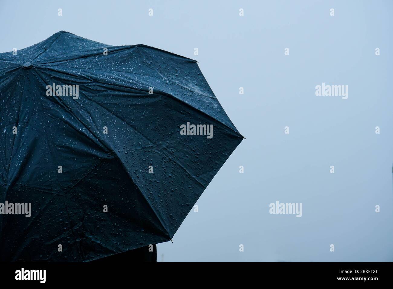 Alone man standing out in rain with an umbrella Stock Photo - Alamy
