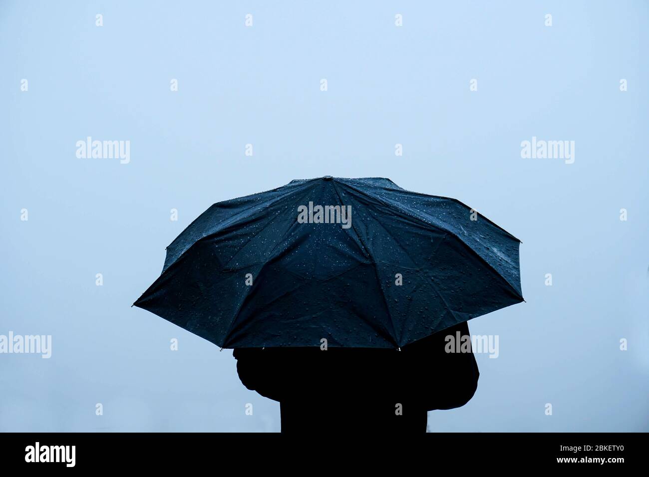 Alone man standing out in rain with an umbrella Stock Photo - Alamy