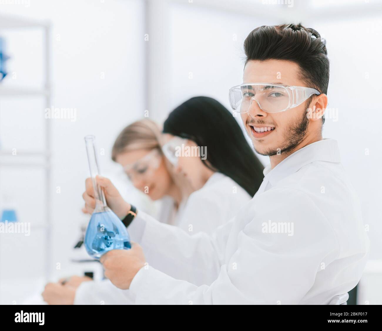 young scientist shows a beaker with liquid Stock Photo - Alamy